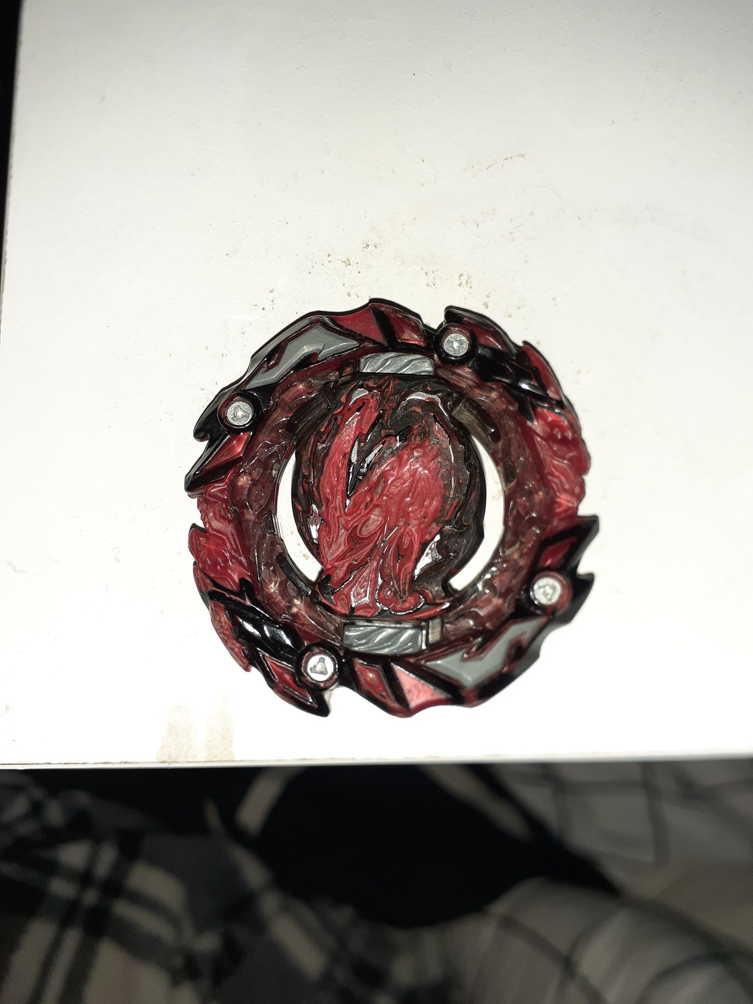 Red and black bey blade, with a red glow, in a bey... - AI Art